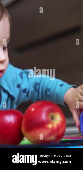 Sweet lovely child lies on the floor with some apples in front of him ...