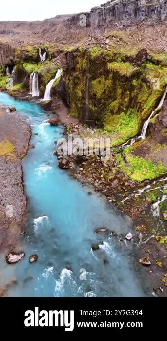 Multiple beautiful waterfalls falling from picturesque mountains into ...