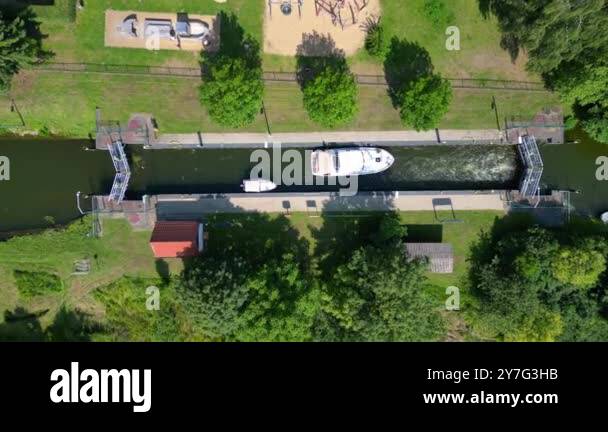 Aerial view of a canal lock sluice being used by boats on a sunny ...