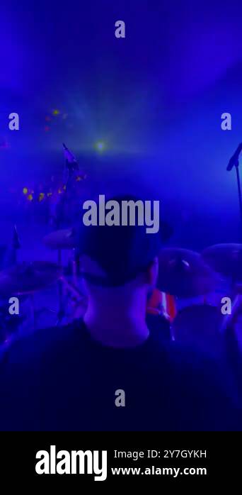Vertical. The drummer cool plays the rock concert. View from behind the ...