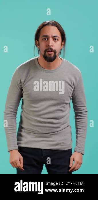 Vertical video Portrait of frightened man covering his face with hands ...