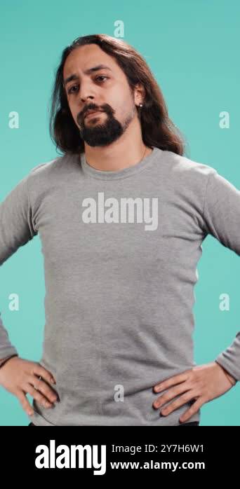 Vertical video Portrait of man standing confidently with hands on hips ...