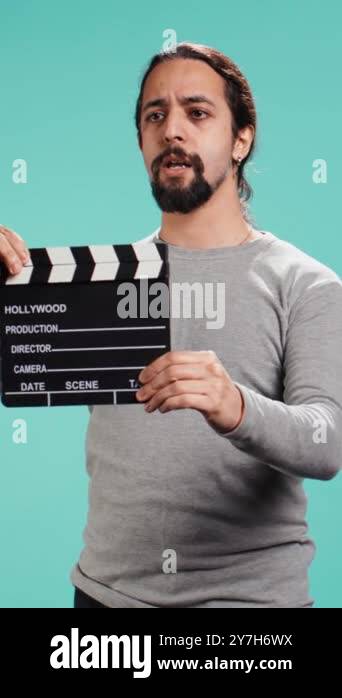Vertical video Movie director using clapper to signal actors beginning ...