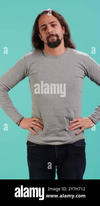 Vertical video Portrait of man standing confidently with hands on hips ...