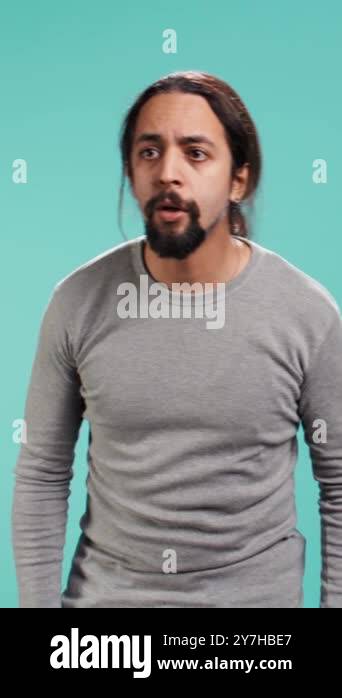 Vertical video Portrait of frightened man covering his face with hands ...