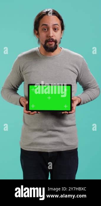 Vertical video Influencer presenting green screen tablet, isolated over ...