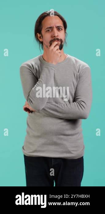 Vertical video Pensive man deep in thoughts, doing ruminating hand ...