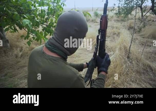 A professional military officer loads his armor and aims his machine ...