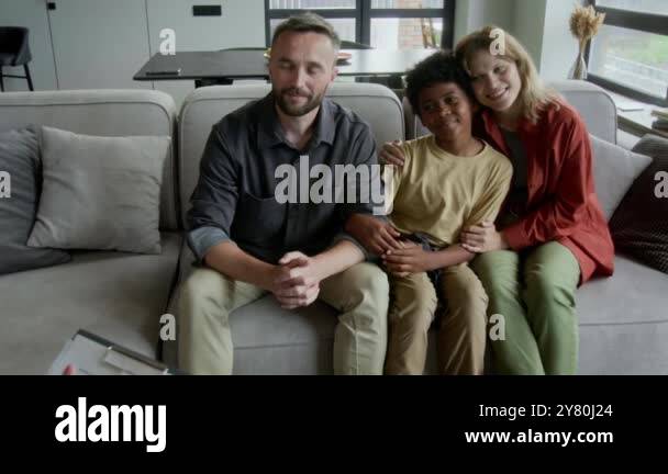 Over-shoulder zoom-out shot of happy young Caucasian adoptive parents ...