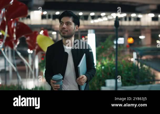 Young programmer with fashionable hairstyle strolling in megapolis and ...