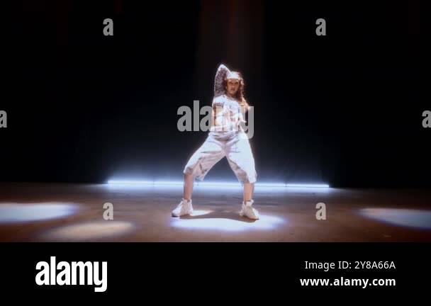 A woman showcases her creative hip hop dance in a studio, energized by ...