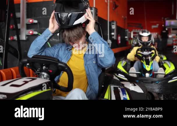Teenage boy in denim shirt putting on his helmet, ready for an exciting ...
