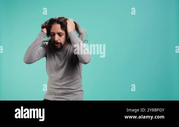 Man pulling hair in frustration, showing angry facial expression ...