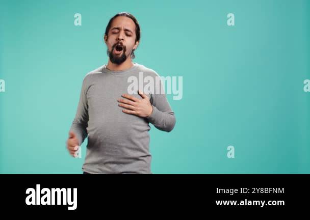 Man feeling exhausted and yawning, covering his mouth, isolated over ...