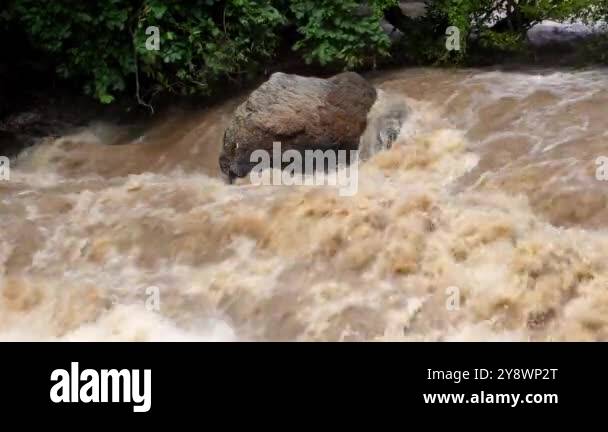 A strong current near a waterfall. Floods flowing in mountain rivers ...