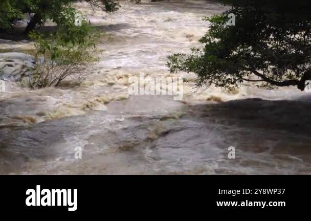 A strong current near a waterfall. Floods flowing in mountain rivers ...