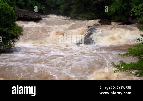 A strong current near a waterfall. Floods flowing in mountain rivers ...