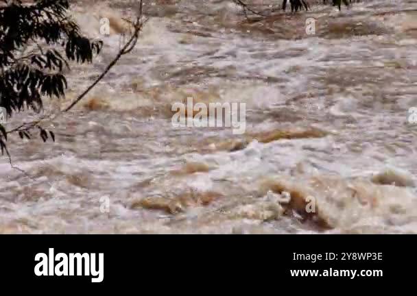 A strong current near a waterfall. Floods flowing in mountain rivers ...