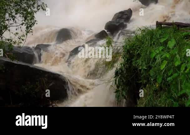 A strong current near a waterfall. Floods flowing in mountain rivers ...