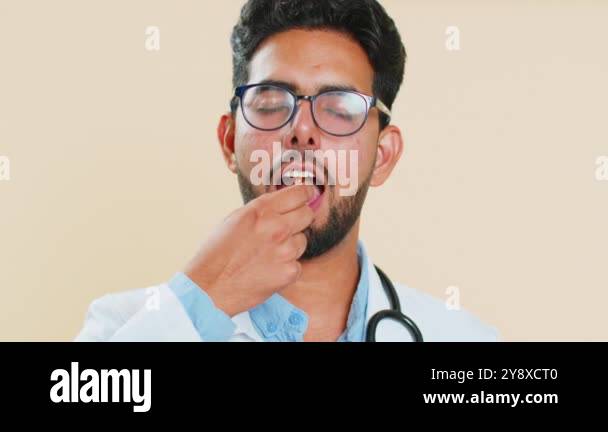 Smiling Indian doctor man puts of tablet pill vitamin D or omega-3 ...