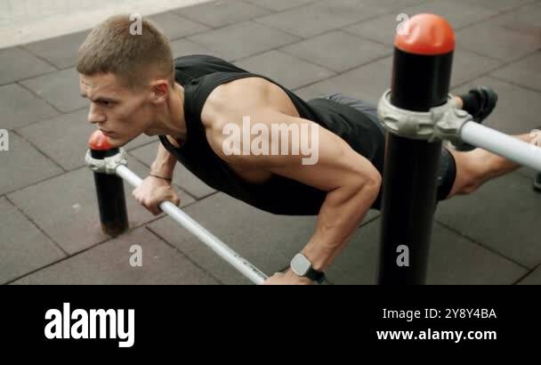 Man with athletic body has morning workout outdoors and doing push up ...