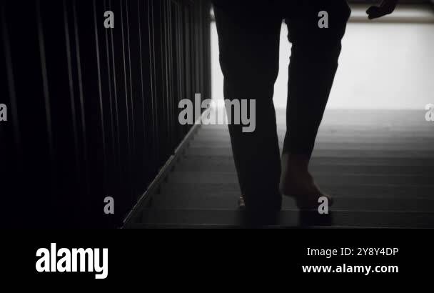 The man descends the stairs in the house from the second floor in the ...