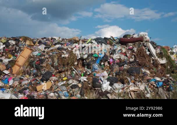 A vast landfill site showcases piles of waste accumulating under a ...