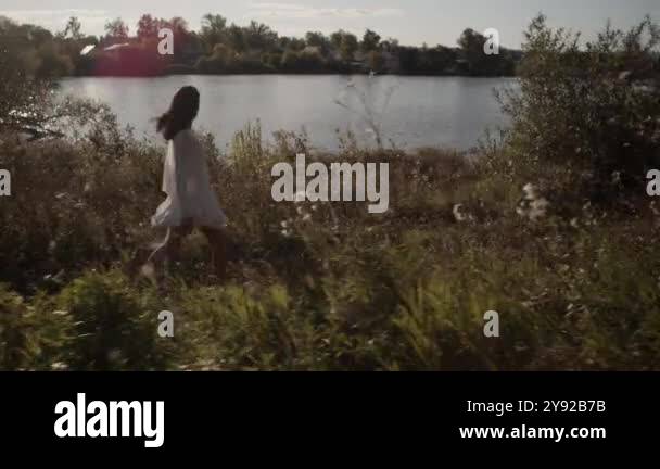 Real time side view of young female fashion model looking away while ...