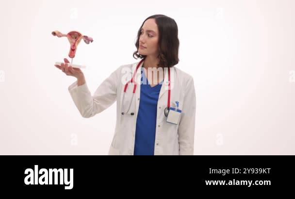Woman gynecologist holds model of uterus and explains structure to ...
