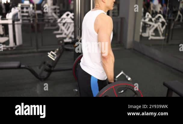 Bodybuilder focuses on back muscles workout lifting heavy barbell in ...