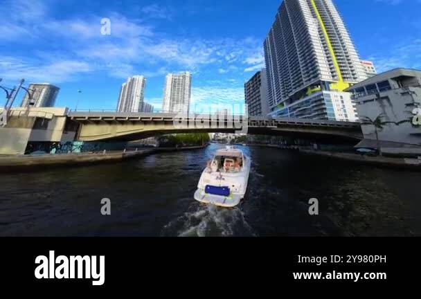Motor boat sails under the bridge in modern city. Low angle view at the ...