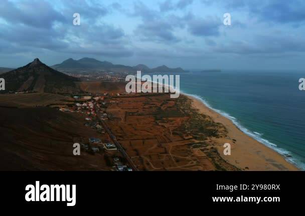 Plain shoreline with a town located on it. Dramatic cloudscape in the ...