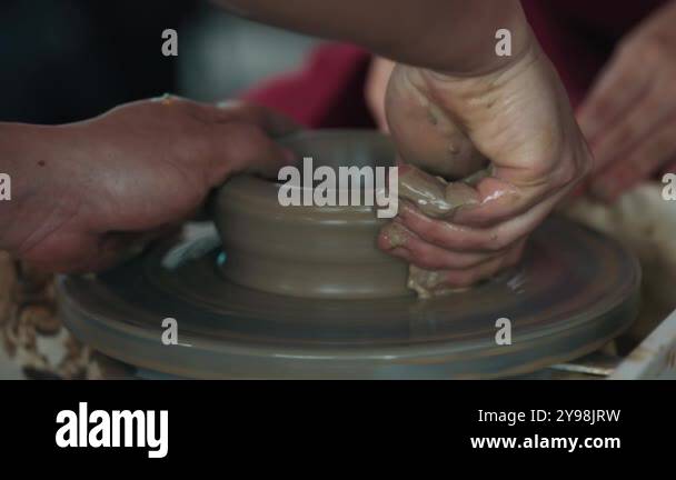 Close up hands of pottery teacher showing right position of palms on ...