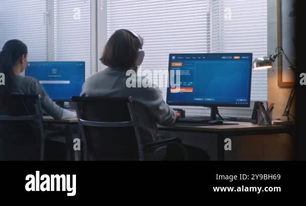 Back view: Two diverse workers using AI generator on computers in office. PC screens showing ...