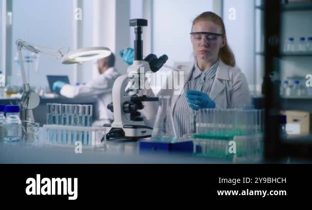 Young female microbiologist, chemist takes sample of medicine or ...