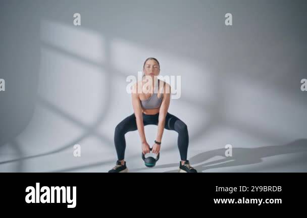 Strong model lifting weight equipment at grey wall background. Young ...