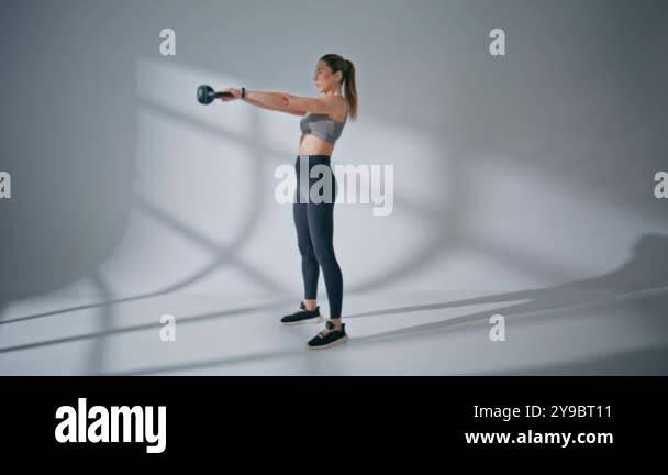 Strong lady lifting kettlebell in gym. Healthy woman training with ...