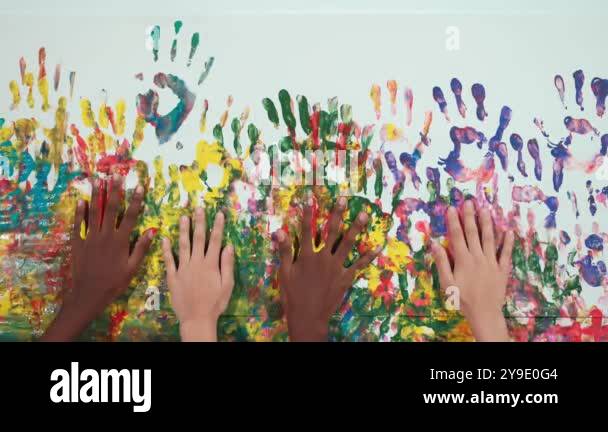 Diverse student hand placed on colorful stained wall while switch place ...