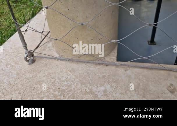 front of the facade with balconies is tensioned cable network covering ...