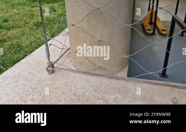 front of the facade with balconies is tensioned cable network covering ...