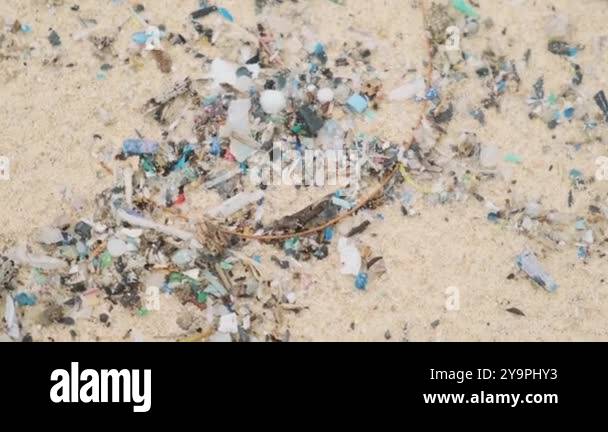 Sea shore pollution. Close up of microplastic particles and debris on ...