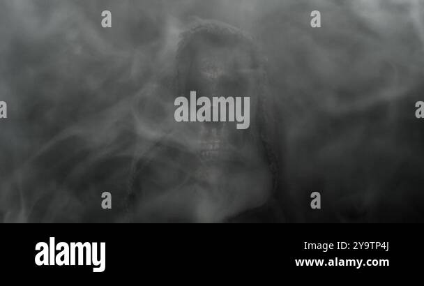 Smoke surrounding mysterious hooded figure with spooky human skull ...