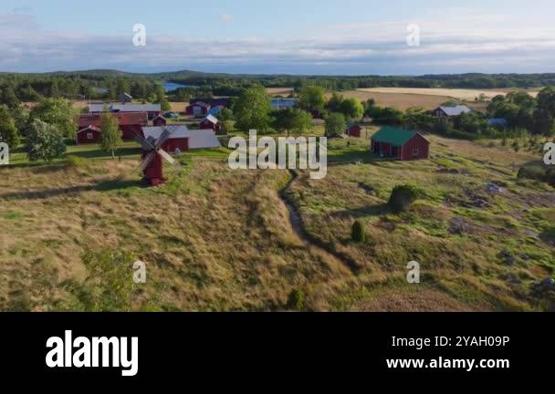 Camera panning across a traditional Finnish farm reveals red buildings ...