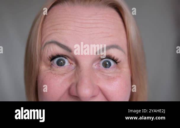 amazed surprised pretty caucasian girl looks at camera wide open eyes ...