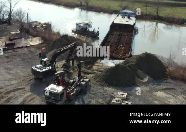 Above view over excavator, tow truck and tugboat as they pull out part ...