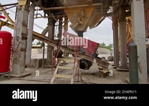 Industrial machinery setup with a red hopper, conveyor belt, and ...