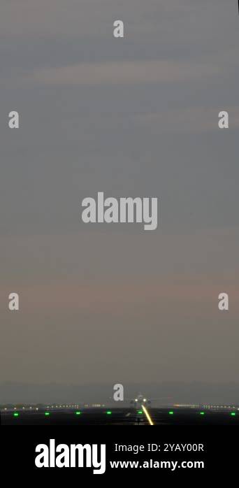 Vertical video of an airplane taking off from a runway at dusk, with ...