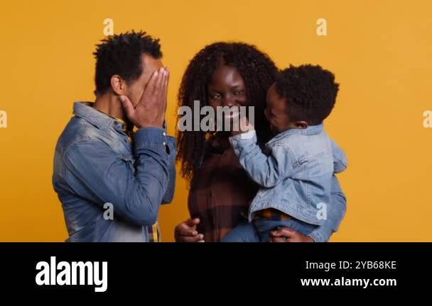 African american positive couple doing peek a boo with their young ...