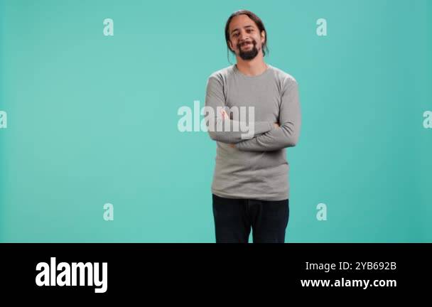 Portrait of joyous man holding hands together, smiling, looking pleased ...