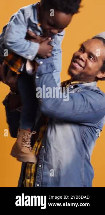 Vertical Video Affectionate loving father carrying his son and playing ...